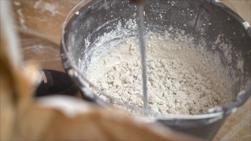 Construction Worker Mixing Plaster in a Bucket on a Construction Site ...