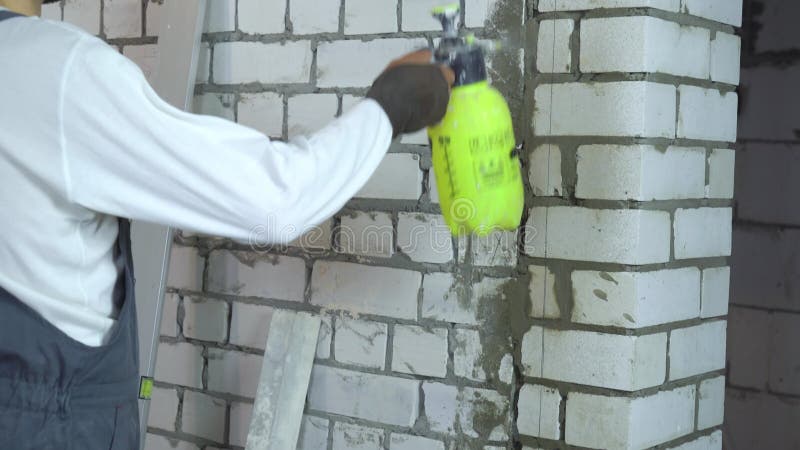 Construction Worker Moisturing Brick Wall with Water Sprayer Stock ...