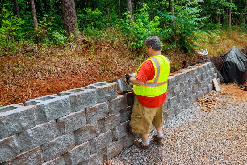 A Construction Worker Mounted Concrete Blocks To Retaining Wall on ...