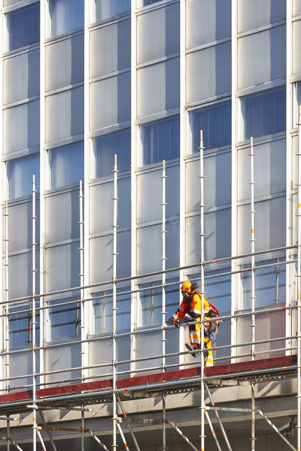 Construction Worker Mounting a Scaffolding Structure on a Building ...