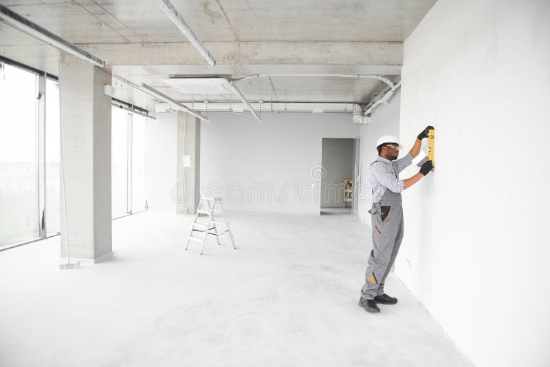 Construction Worker Observing and Surveying Wall Alignment Using Water ...