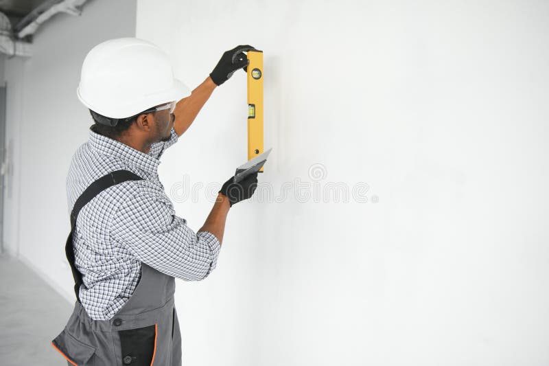 Construction Worker Observing and Surveying Wall Alignment Using Water ...