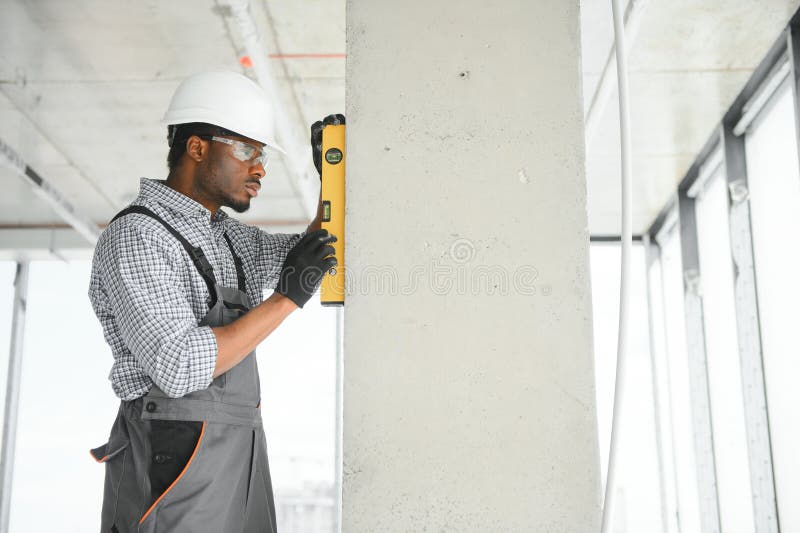 Construction Worker Observing and Surveying Wall Alignment Using Water ...