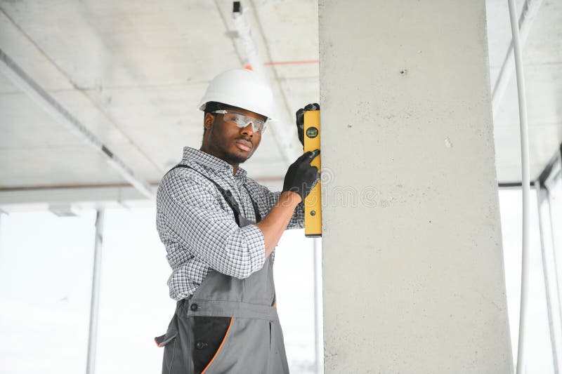 Construction Worker Observing and Surveying Wall Alignment Using Water ...