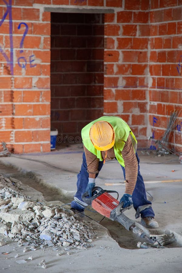 A Construction Worker Operates a Jackhammer, Breaking Ground during a ...