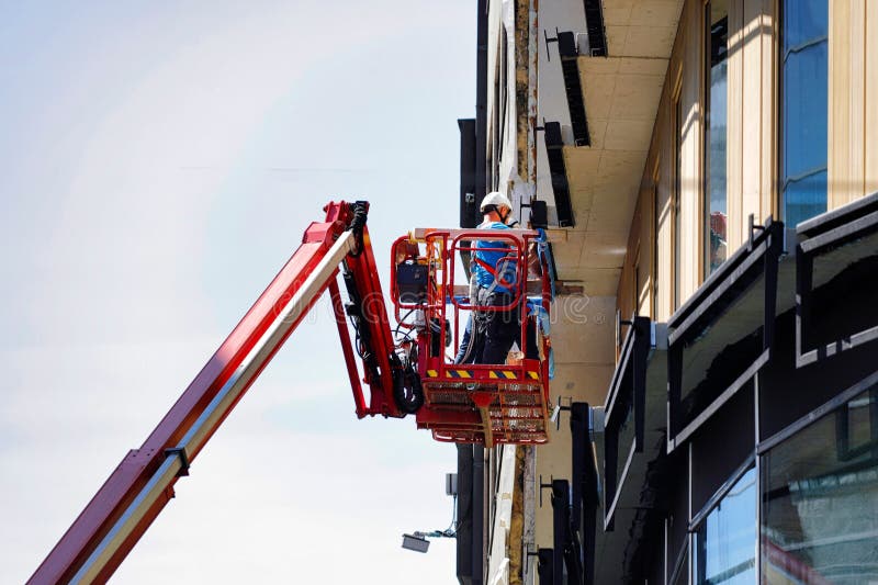 Construction Worker Operating a Cherry Picker while Working on a ...