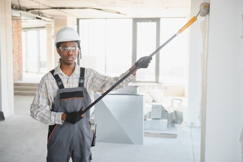 Construction Worker Painting Walls with Telescopic Paint Roller Stock ...