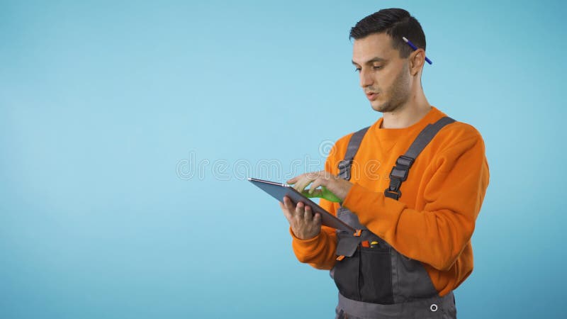 Construction Worker with Pen Behind Ear Taking Notes on Tablet ...
