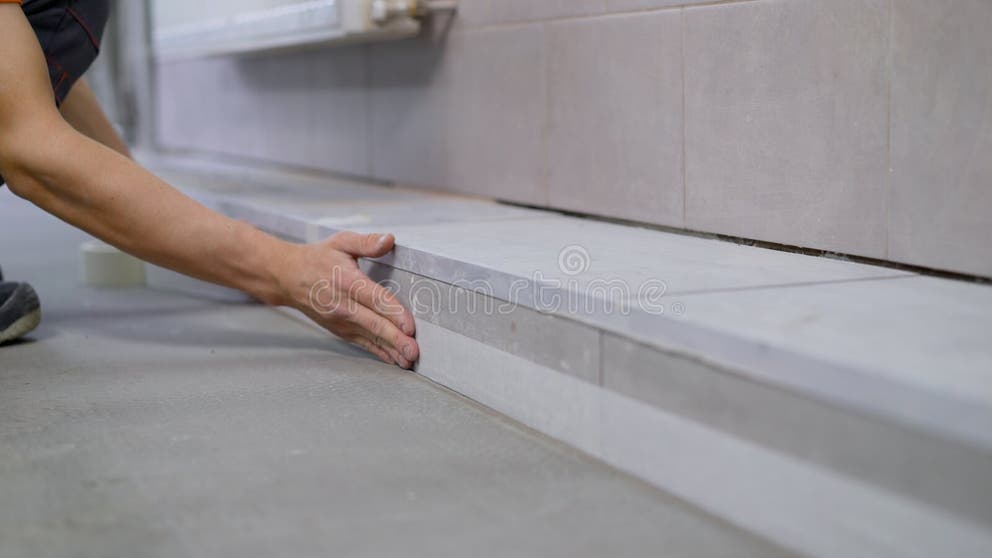 Tiler Installing Large Format Tiles on a Shower Curb in a Bathroom ...