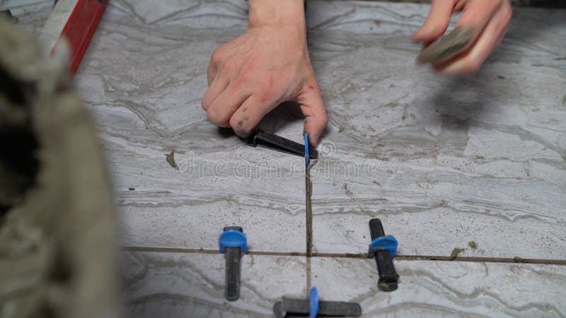 Construction Worker Placing Tile Leveling System Clips during ...