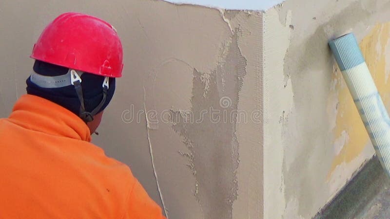 Construction Worker Using a Level Tool To Ensure Wall Alignment at a High-rise Building Site ...