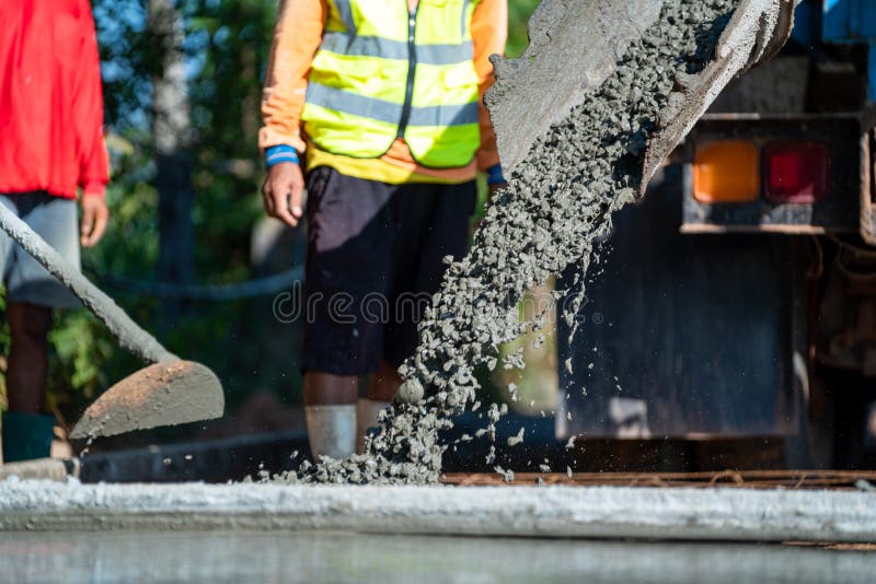 A Construction Worker Pouring a Wet Concret at Road Construction Site ...