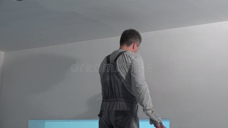 Construction Worker Puts a Finishing Touch on Wall. Man with Polishing ...