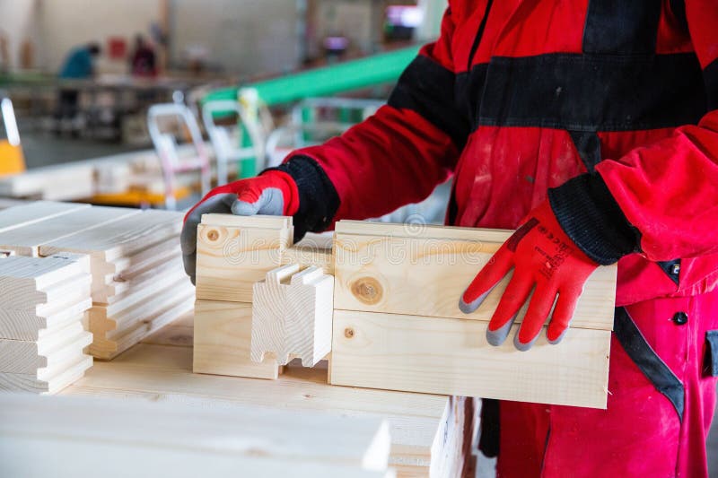Construction Worker in Red Workwear Working with a Wooden Structure on ...