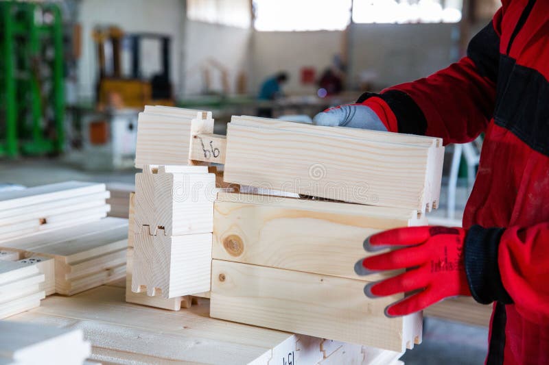Construction Worker in Red Workwear Working with a Wooden Structure on ...