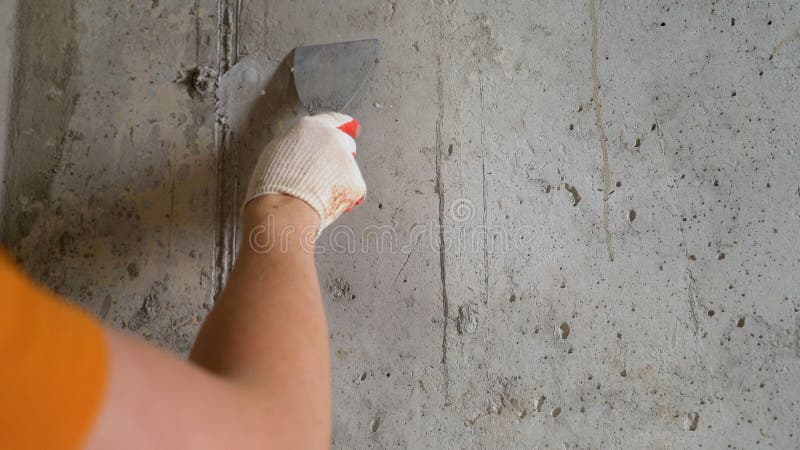 Construction Worker Removing Excess Concrete from Wall with Putty Knife ...