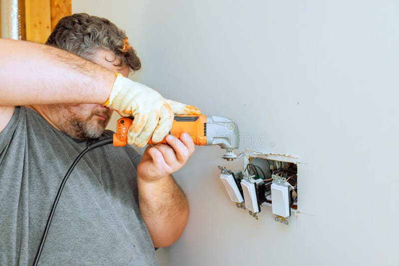Man Using Electric Tool for Home Renovation while Upgrading Electrical ...