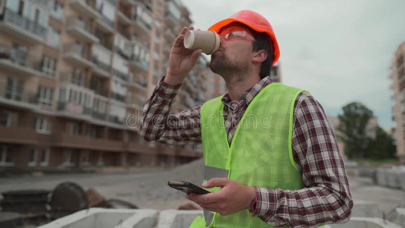 Construction Worker Resting on Building Site Drinking Coffee To Go and ...