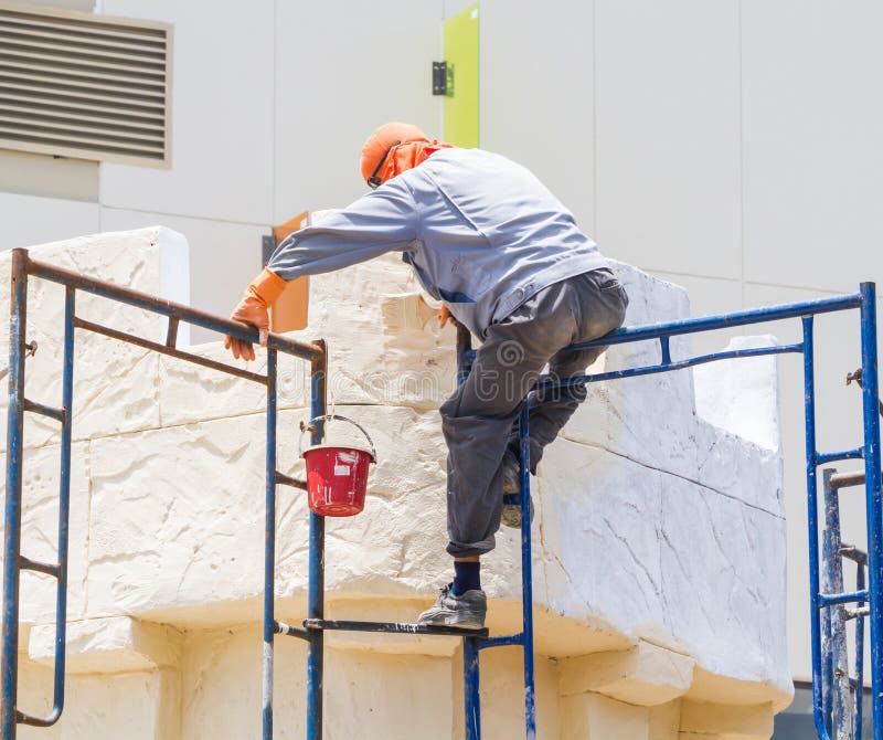 Construction Worker Restoring and Painting Outside the Building. Stock ...