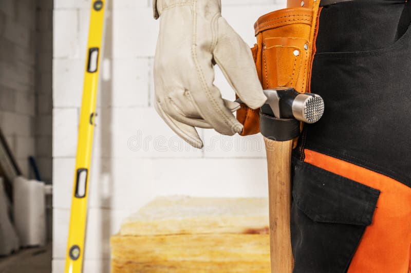 Construction Worker Retrieving Hammer from Tool Belt in Construction ...