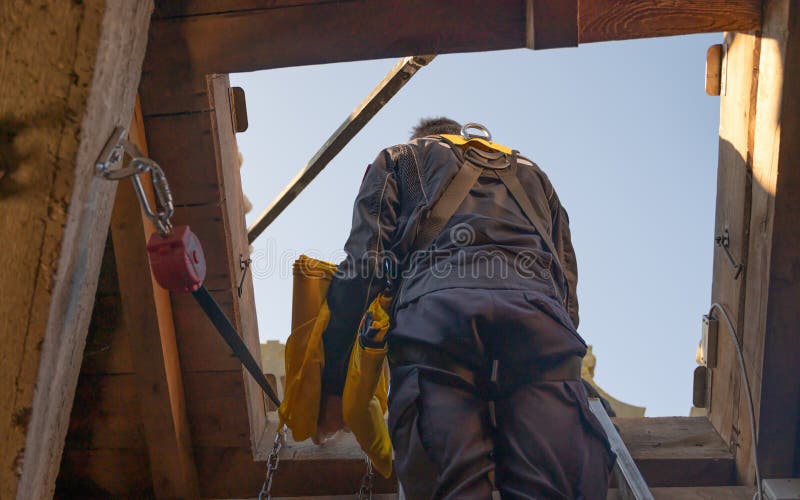 A Worker Climbs a Ladder in Proper Safety Gear To Ensure Protection and ...