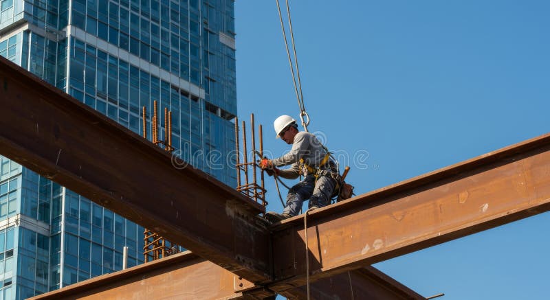 A Construction Worker in Safety Gear Works on a Steel Structure High ...