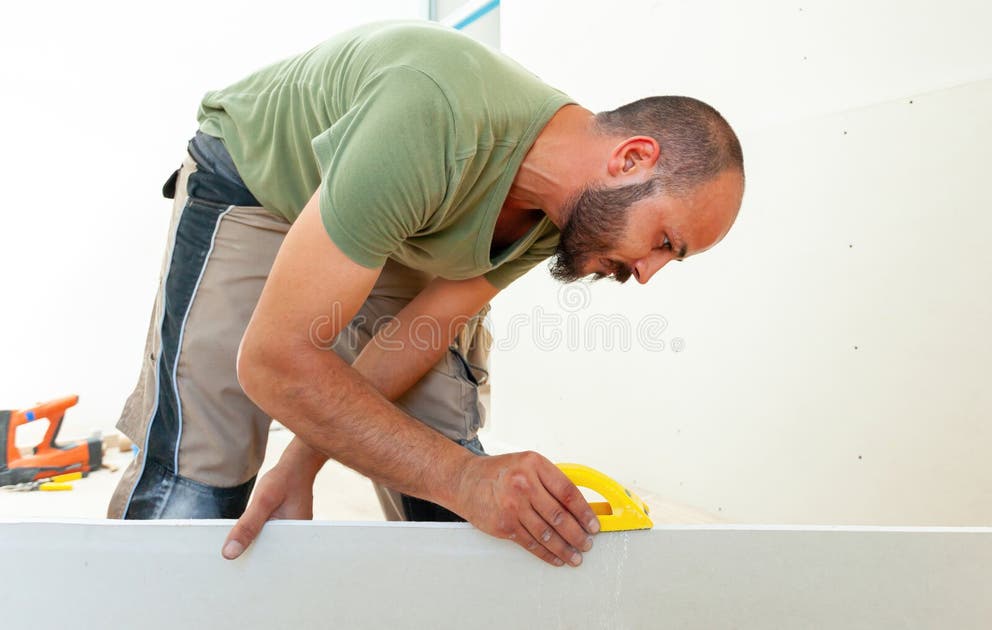 Construction Worker Sanding Drywall with Hand Sander during Home ...