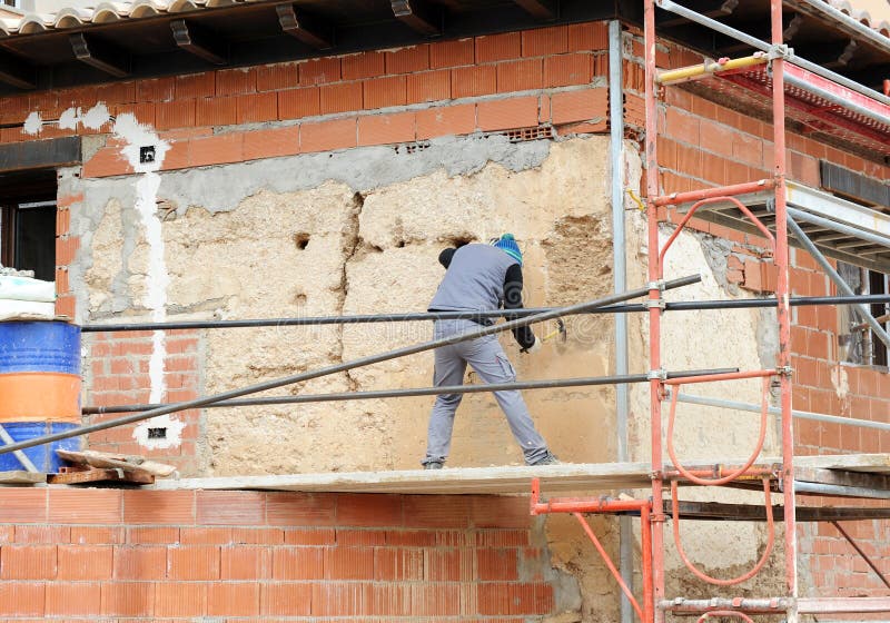Construction Worker on Scaffold Using the Pickaxe in an Old Wall. Stock ...