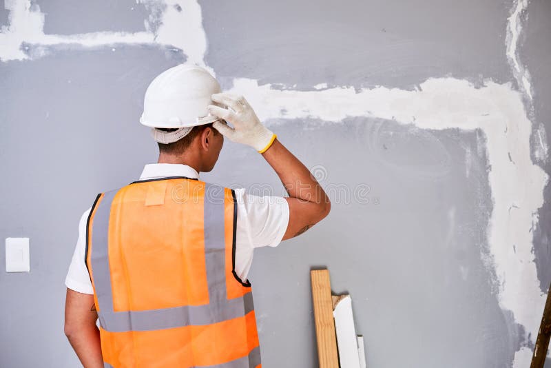 A Construction Worker Scratches Head in Confusion while Looking at ...