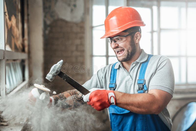 Crazy Contractor Strikes with a Hammer, Screaming and Smiling Stock ...