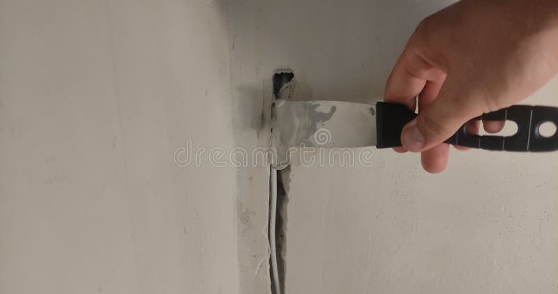 A Construction Worker Seals the Electrical Cable Laid in the Wall with ...