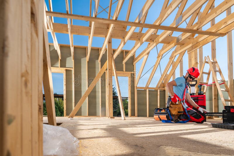 Construction Worker Securing Wooden Beams Inside a New Home Under ...