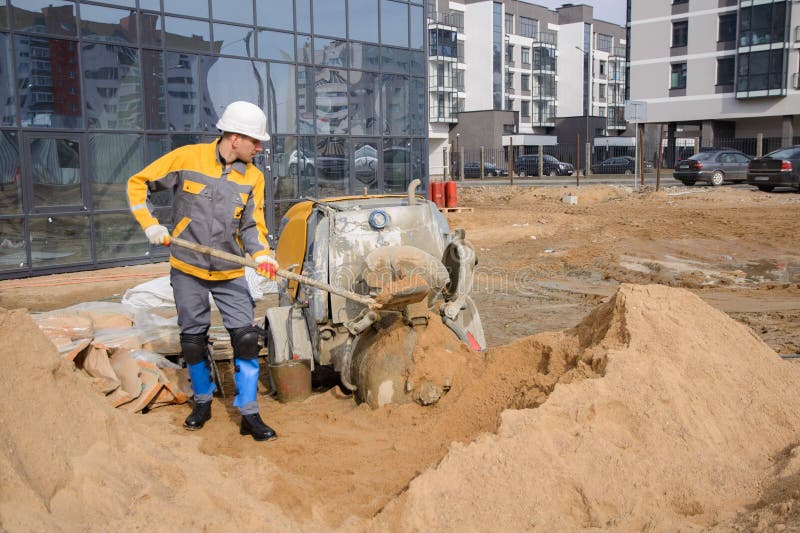Construction Worker with Shovel and Bucket on Construction Site of New ...