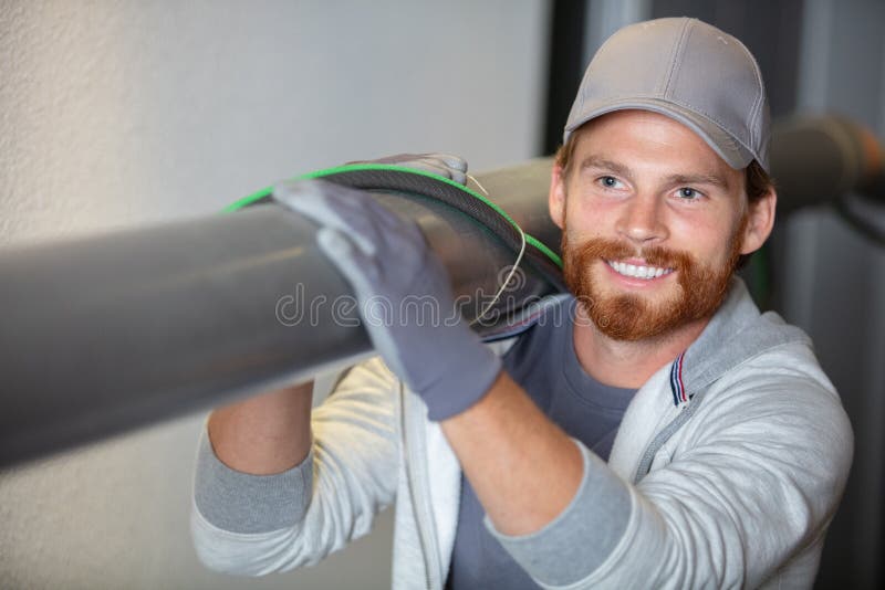 Construction Worker on Site Carrying Pipe on Shoulder Stock Image ...