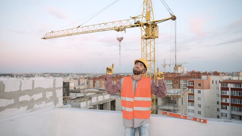 Construction Worker on Site at Sunset, Overseeing Progress of High-rise Building in Urban ...