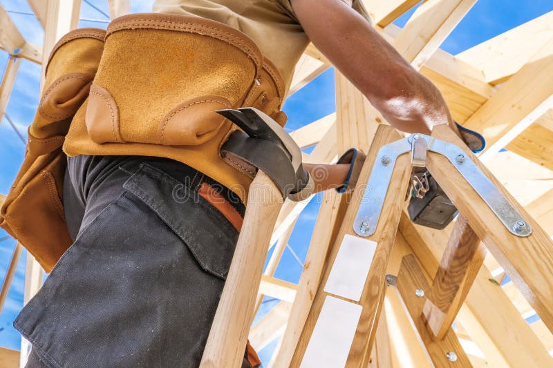 Construction Worker Using a Wooden Ladder To Build a Structure Under a ...