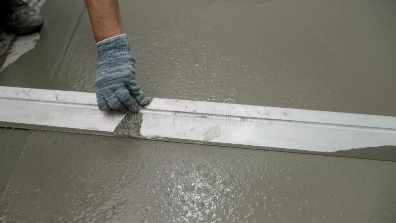 Construction Worker Leveling Concrete Surface with a Screed Stock ...