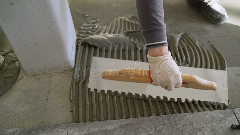 Construction Worker Applying Tile Adhesive To Floor with Notched Trowel Stock Photo - Image of ...