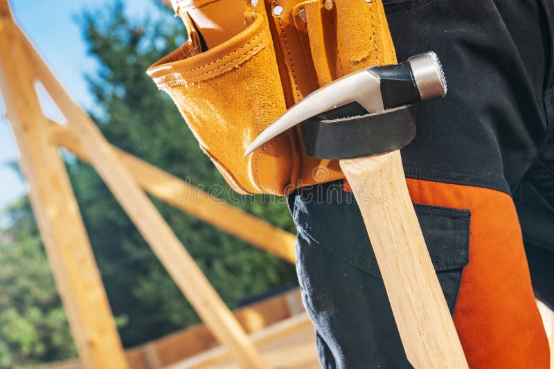 Construction Worker Holding a Hammer Stands Ready on a Job Site with ...