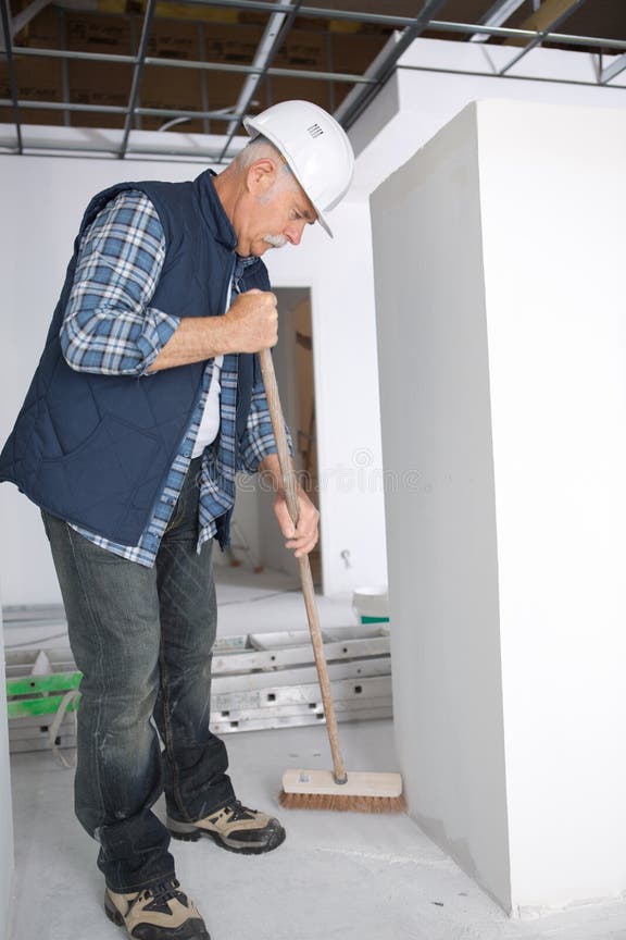 Construction Worker Sweeping Dust with Broome at Construction Site ...