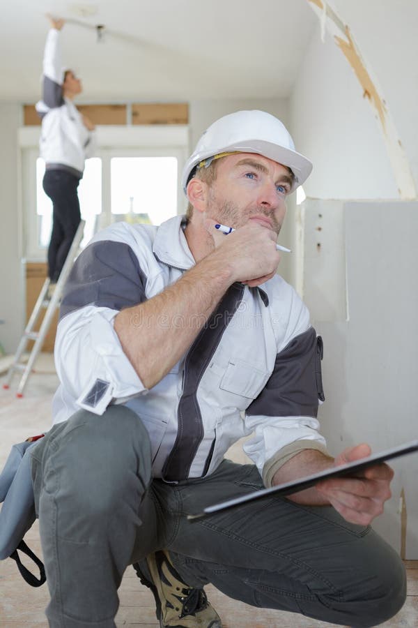 Construction Worker Taking Notes on Clipboard in New House Stock Photo ...