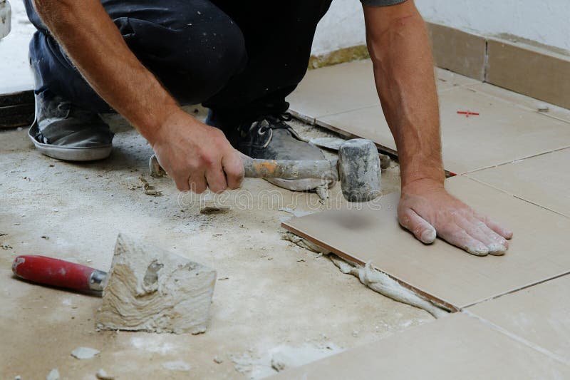 Construction Worker is Tiling Floor at Home. Laying Tiles on the Floor ...