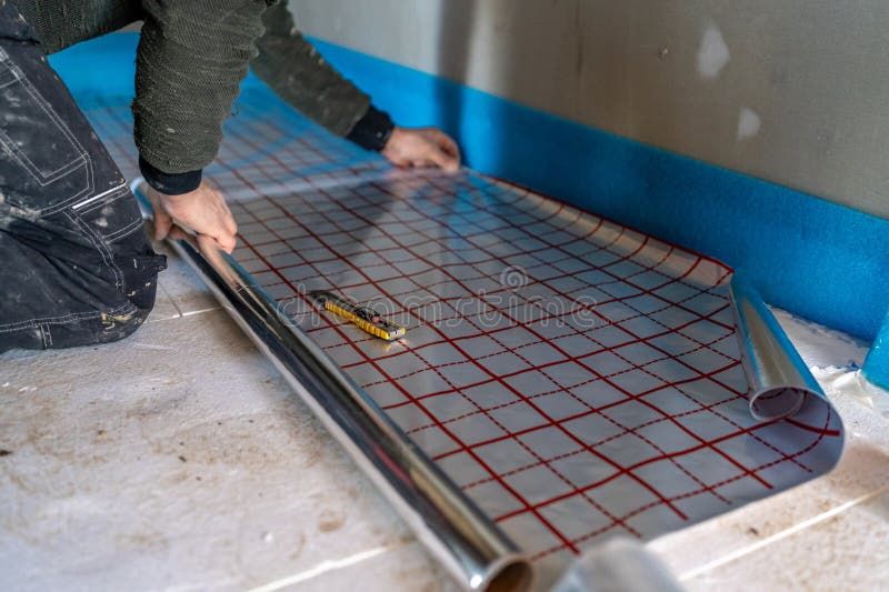 Construction Worker Installing Aluminum Foil Insulation on Floor for ...