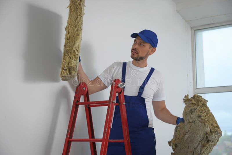 Construction Worker with Used Glass Wool on Stepladder in Room Prepared ...