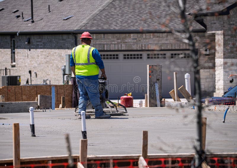 A Construction Worker Uses a Concrete Finishing Machine To Smooth a ...