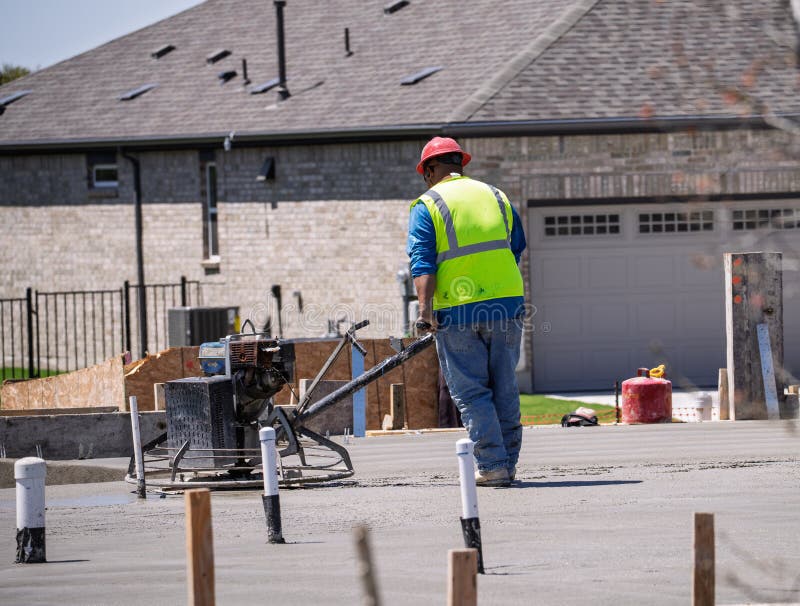 A Construction Worker Uses a Concrete Finishing Machine To Smooth a ...