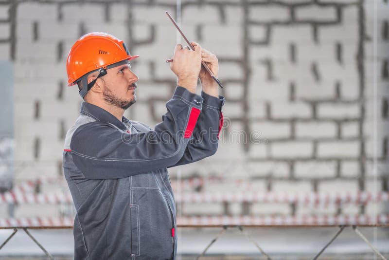 A Construction Worker Uses Modern Digital Technologies in the Process ...