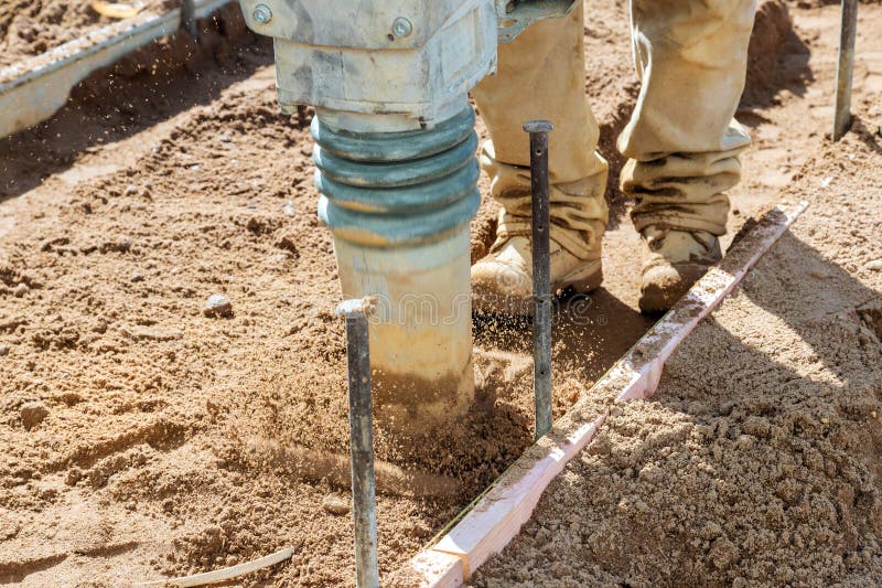 Construction Worker Uses Rammer To Compact Soil at Building Site during ...