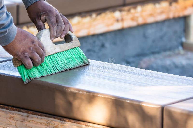 Construction Worker Using Brush on Wet Cement Forming Coping Around New ...