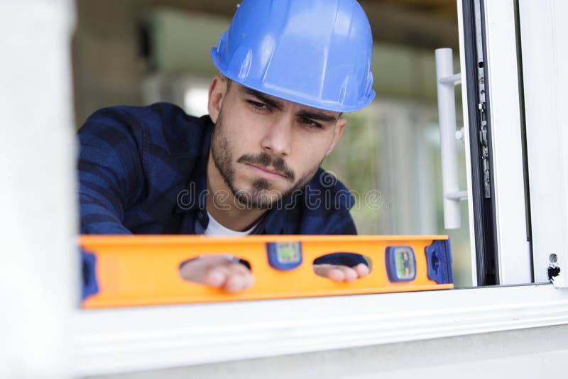 Construction Worker Using Bubble Level while Installing Window Indoors ...